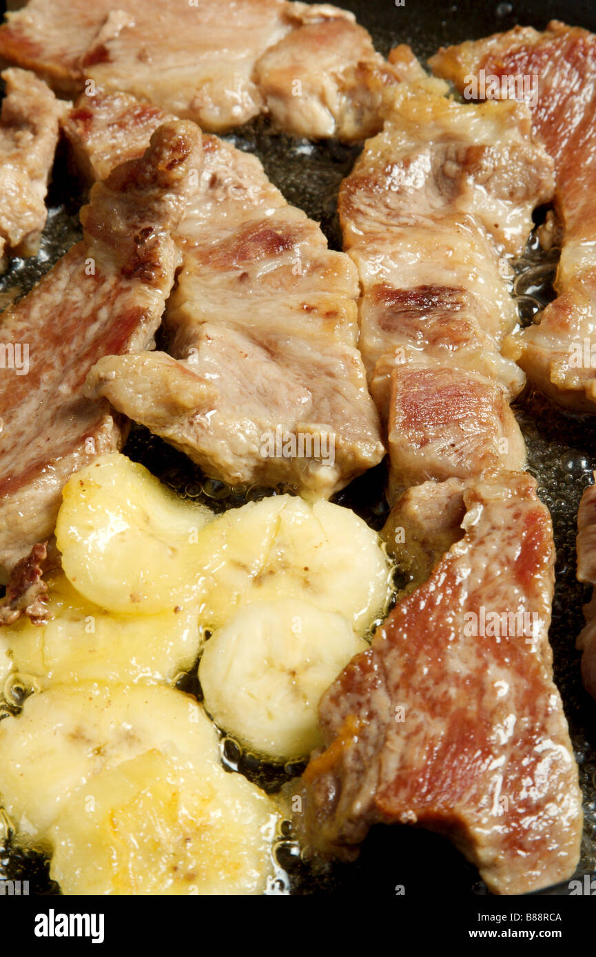 Preparation of slices of pork on a frying pan with the help of gas ...
