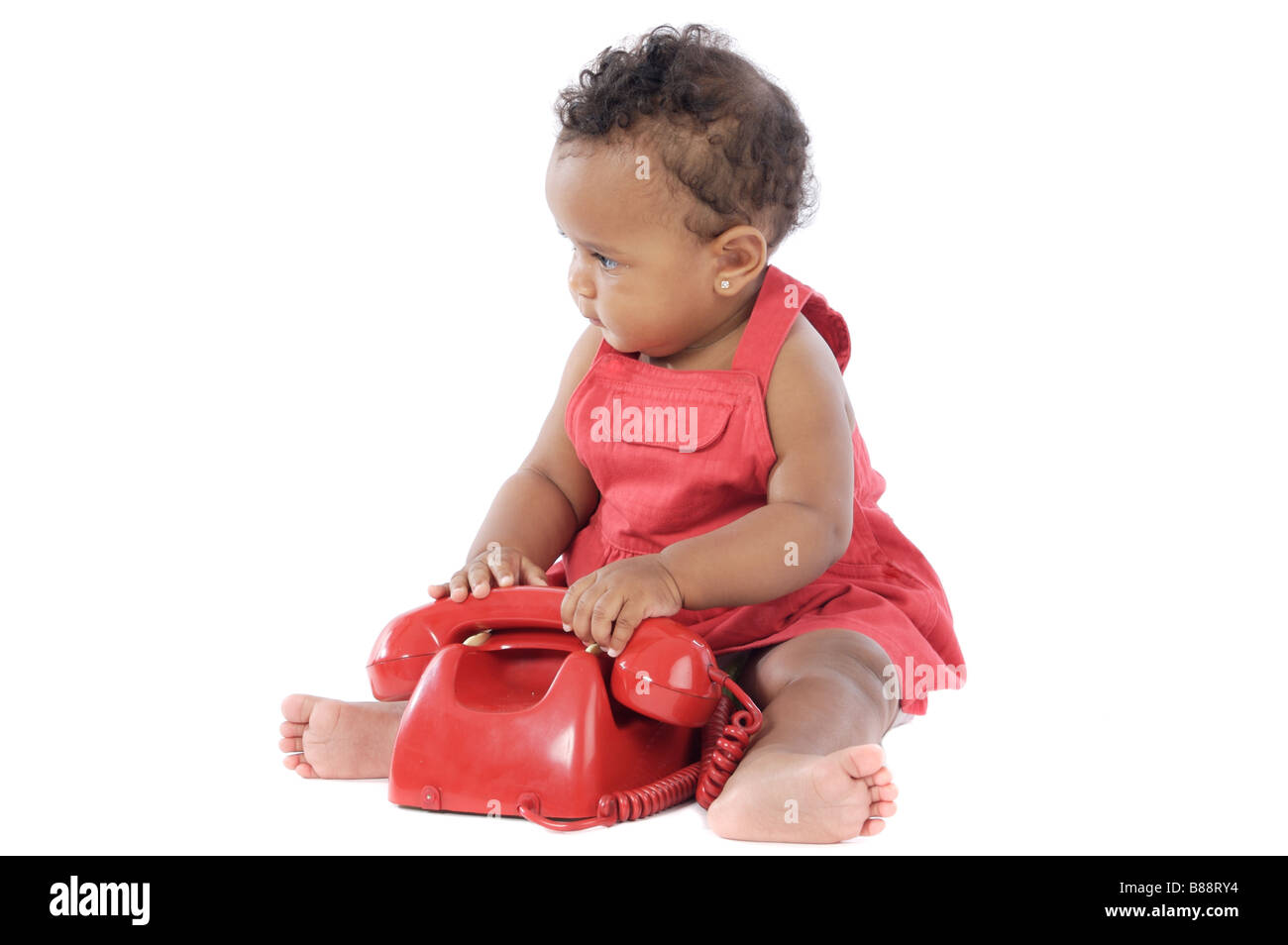 Baby with red phone a over white background Stock Photo - Alamy