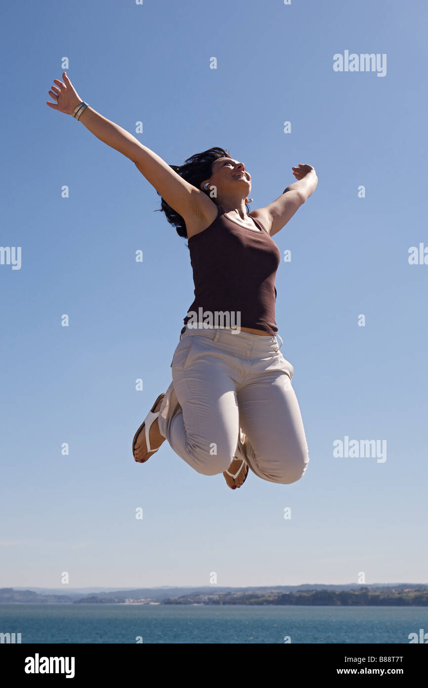 Beautiful girl jumping a over sky background Stock Photo - Alamy