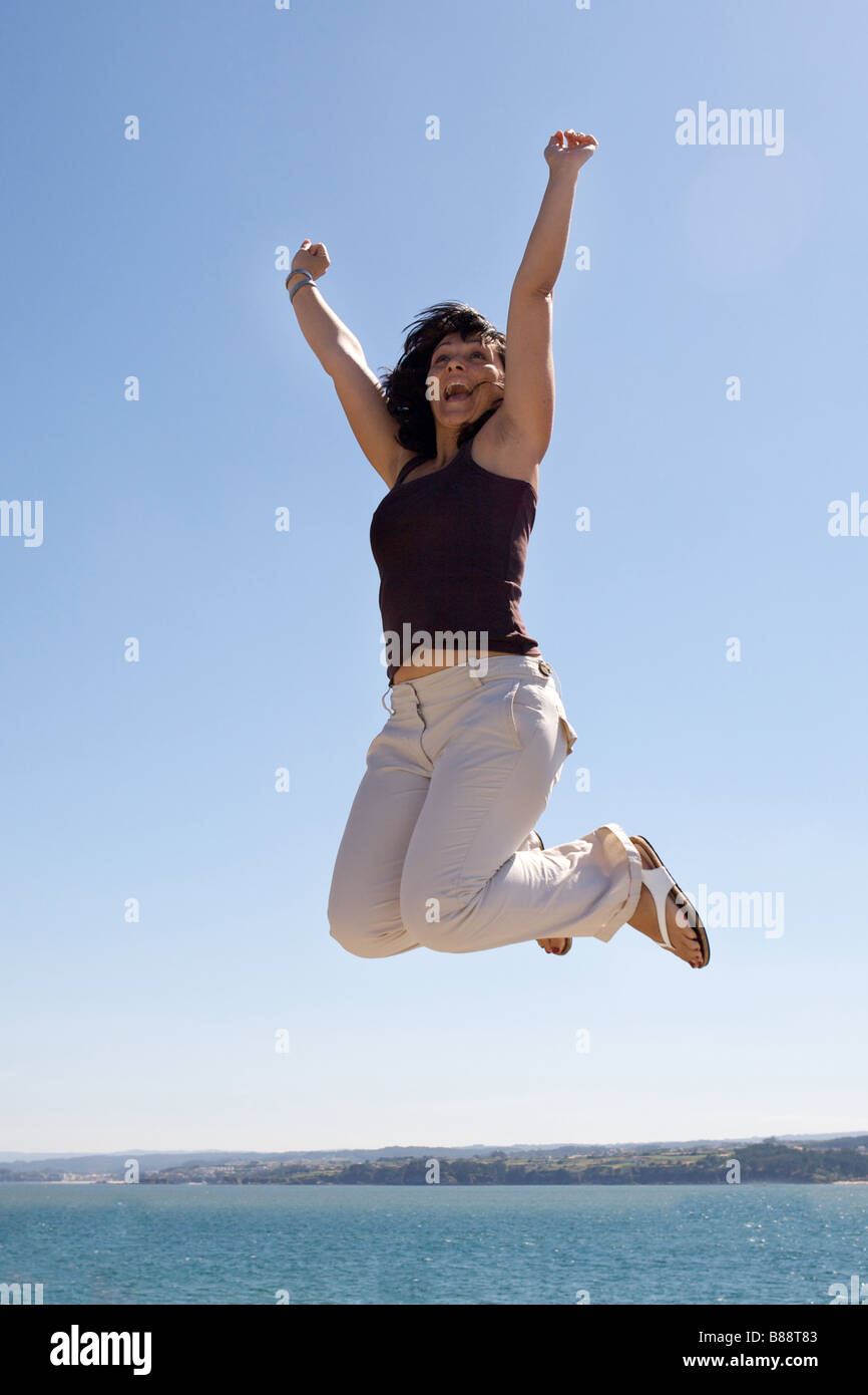 Beautiful girl jumping a over sky background Stock Photo - Alamy