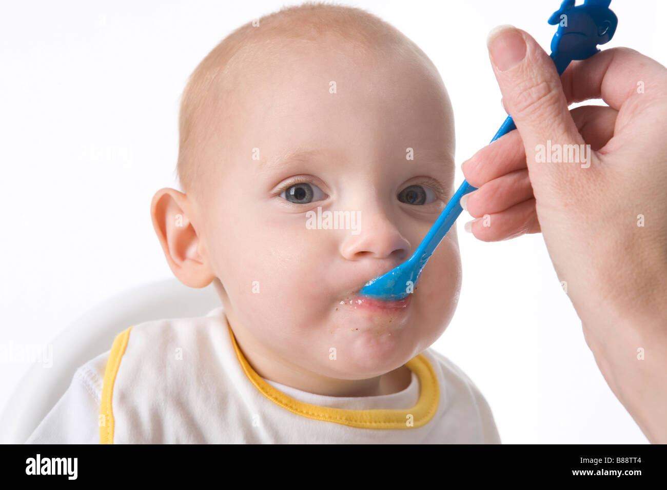 Toddler girl is fed with a spoon Stock Photo - Alamy