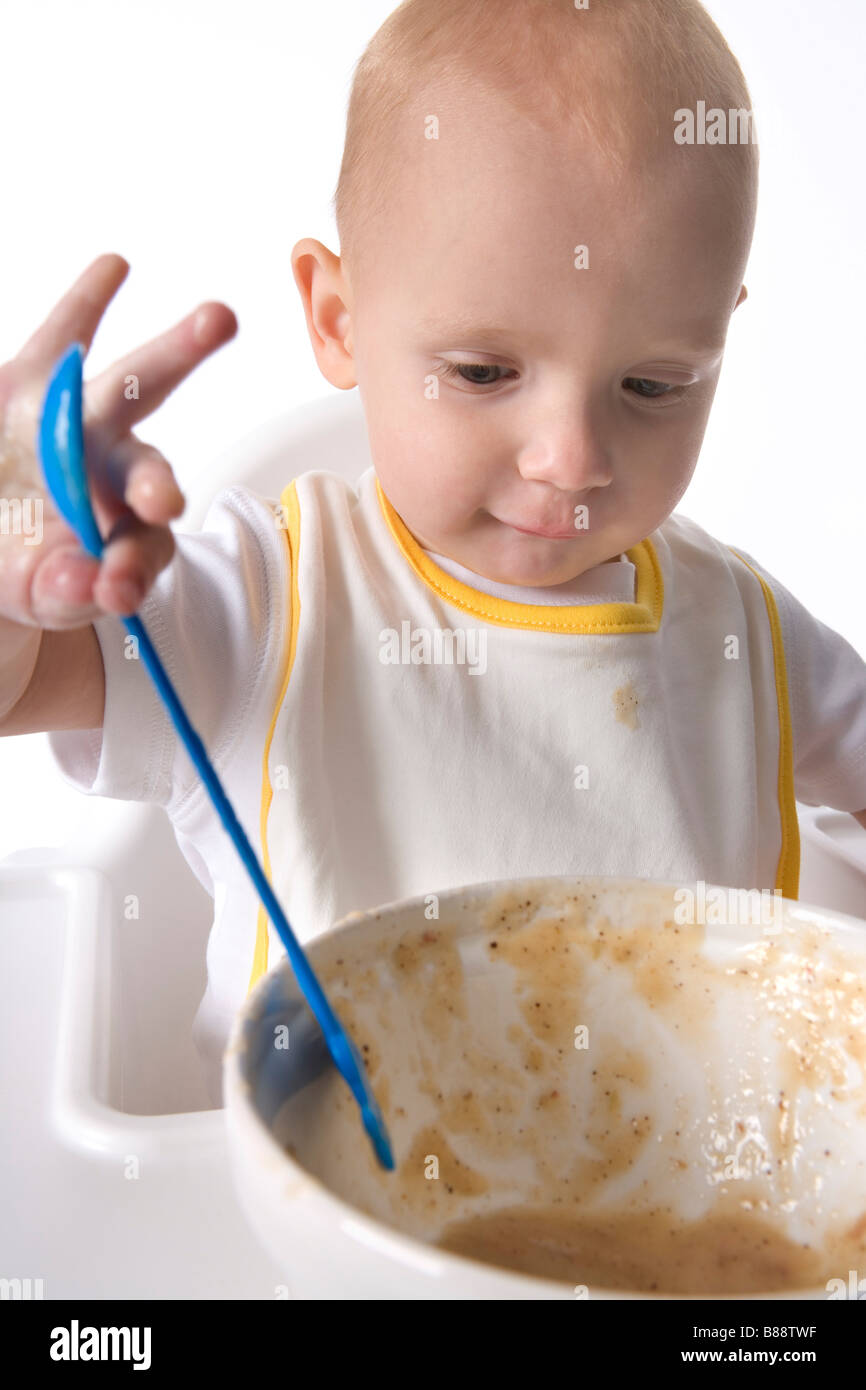 Toddler girl eating by herself Stock Photo - Alamy