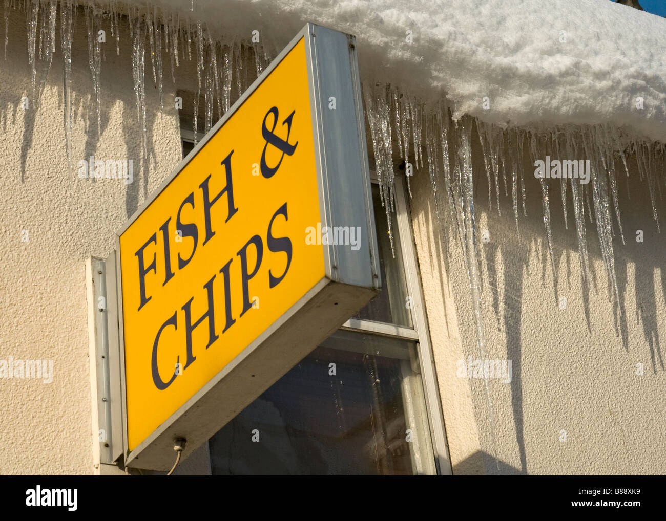 Rooftop Icicles hang above a Fish and Chip sign in the Scottish ...