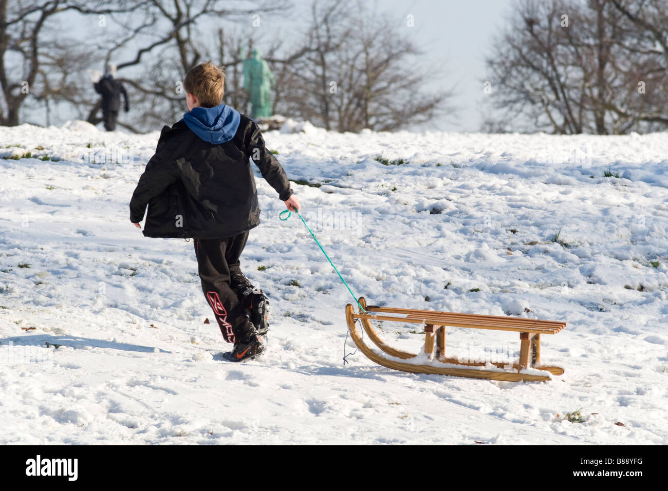 Boy pulling a sledge Stock Photo - Alamy