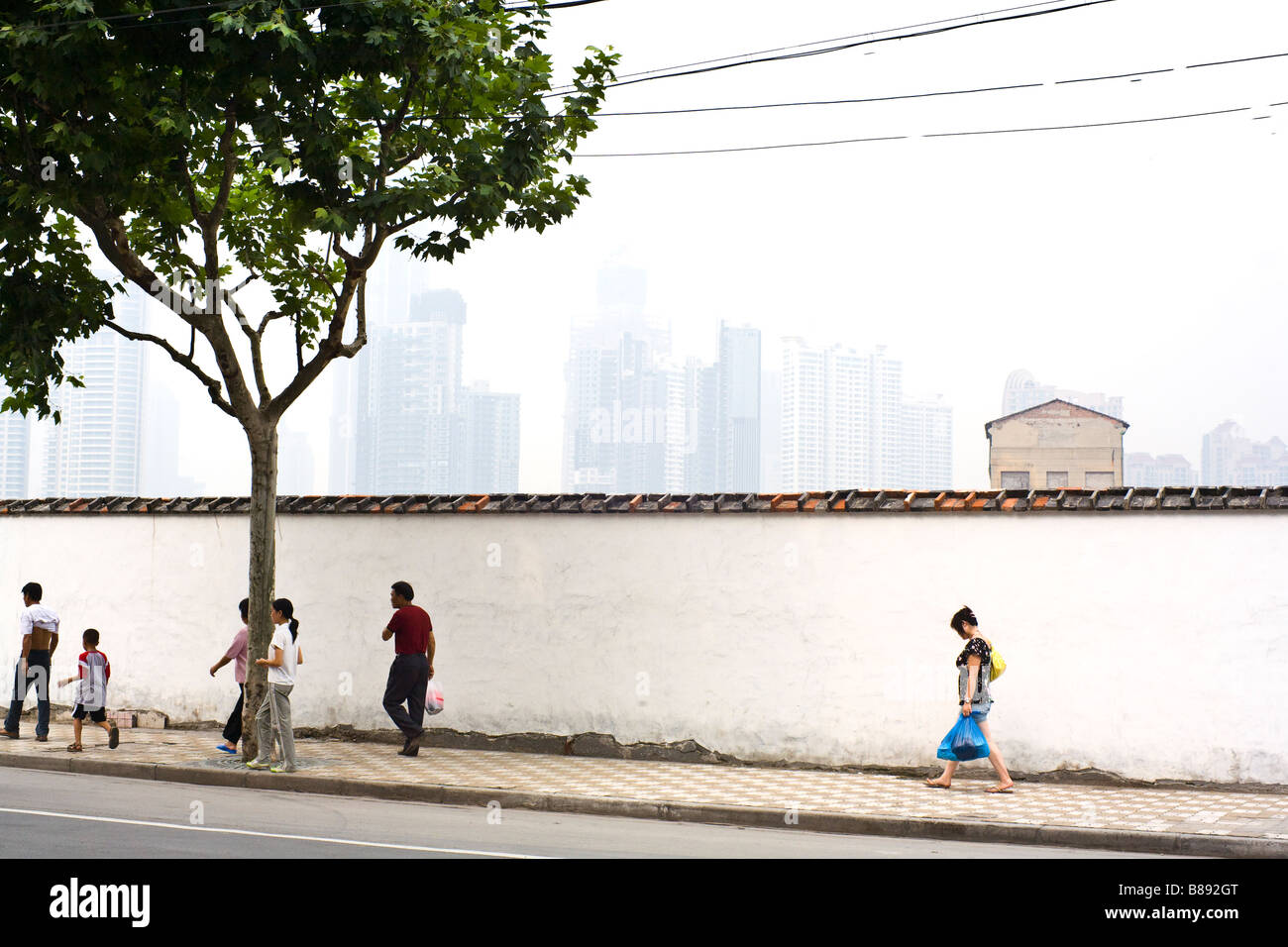 Pedestrians in old Shanghai facing new skyscraper skyline. Old ...