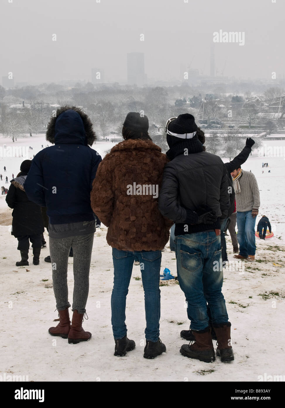 Three young men look over London in the snow Stock Photo - Alamy