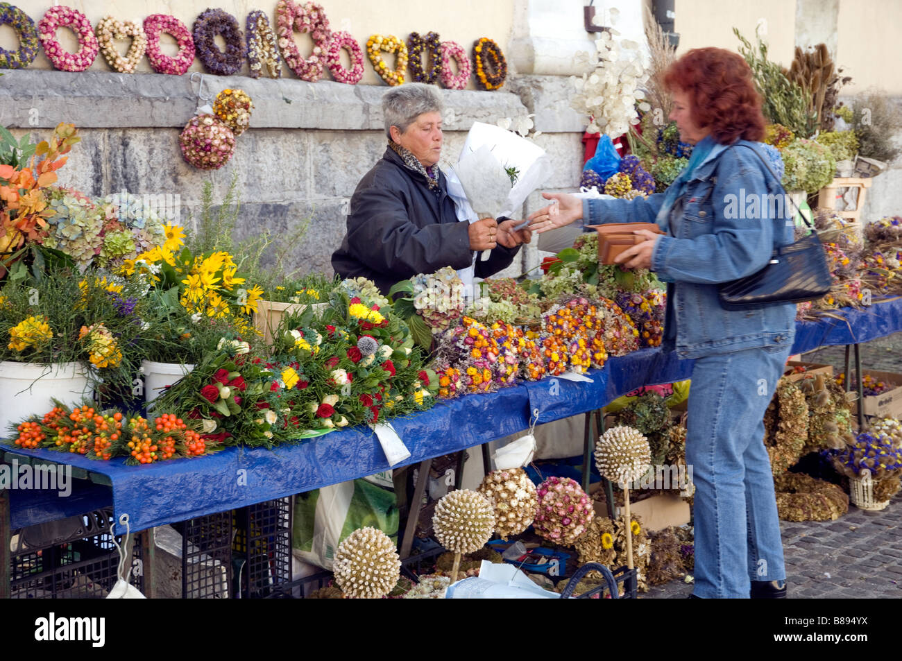 A lady selling flowers at an outdoor Ljubljana flower market Stock ...