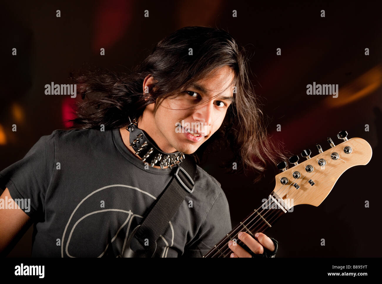 Rock singer playing guitar against a dark background Stock Photo - Alamy