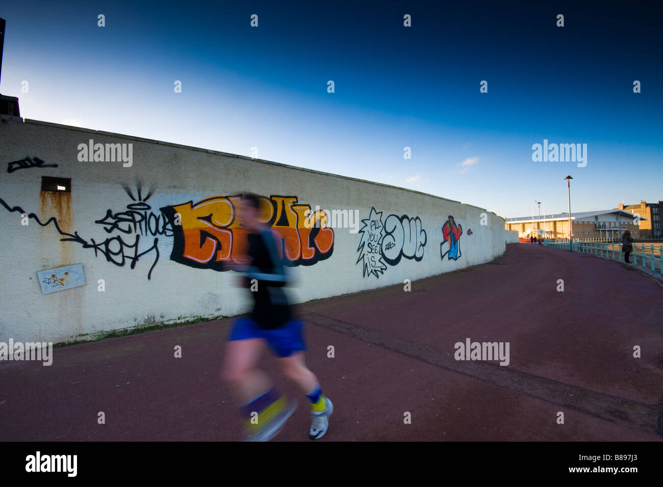 jogging past graffiti Stock Photo - Alamy