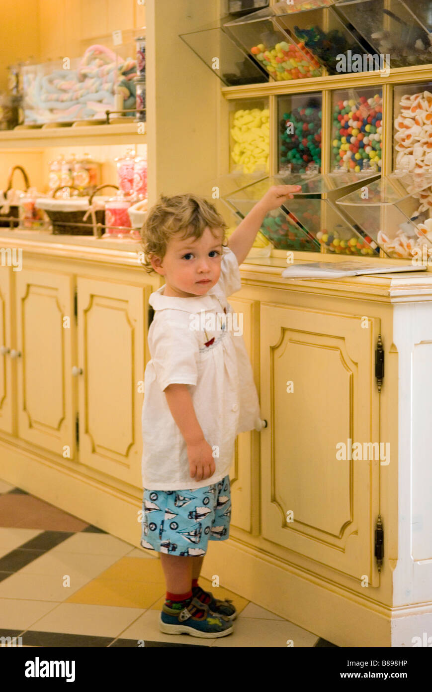 Young boy stealing sweets from sweet shop Stock Photo - Alamy