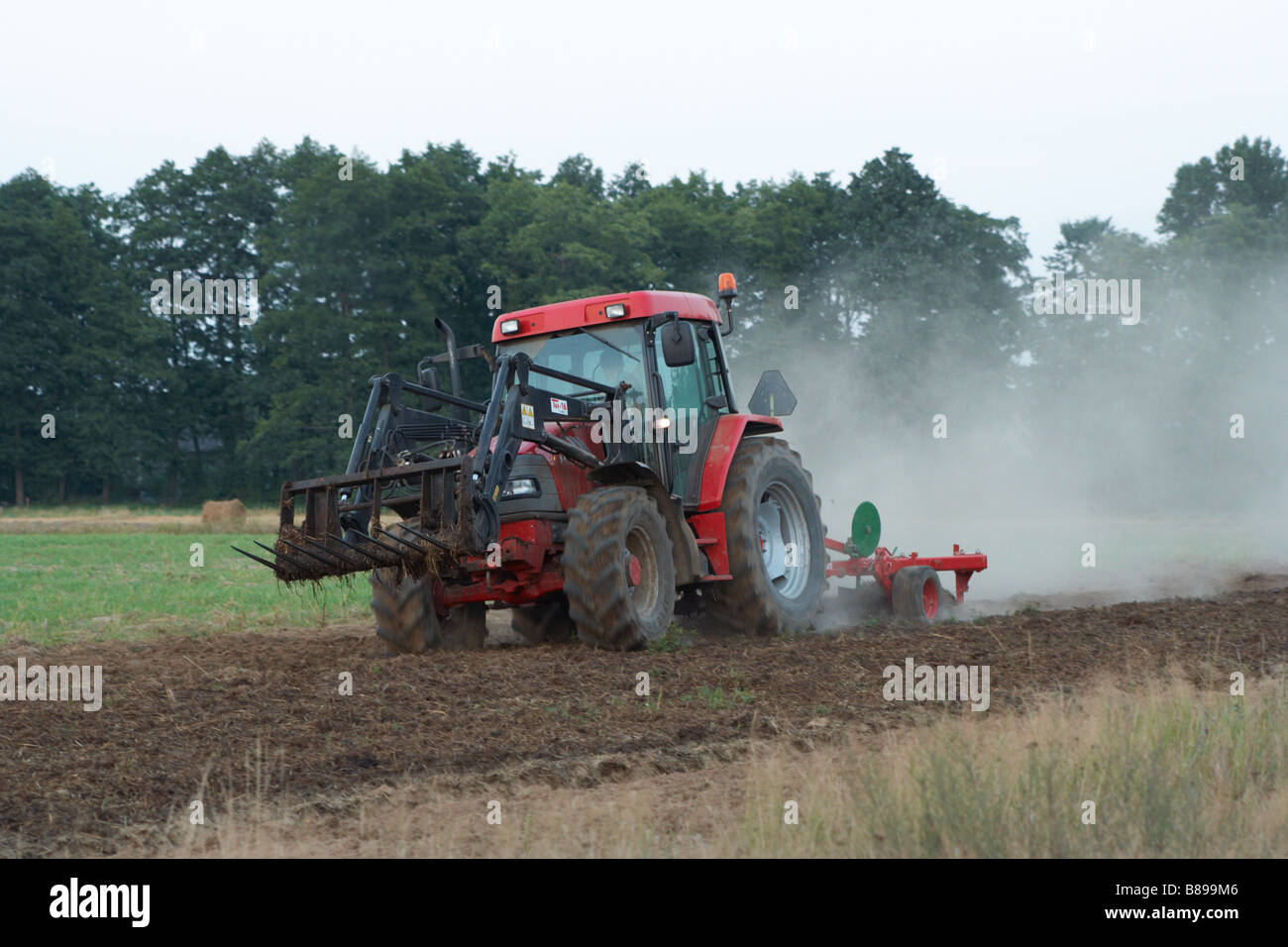 Farmer riding on a farm tractor Stock Photo - Alamy