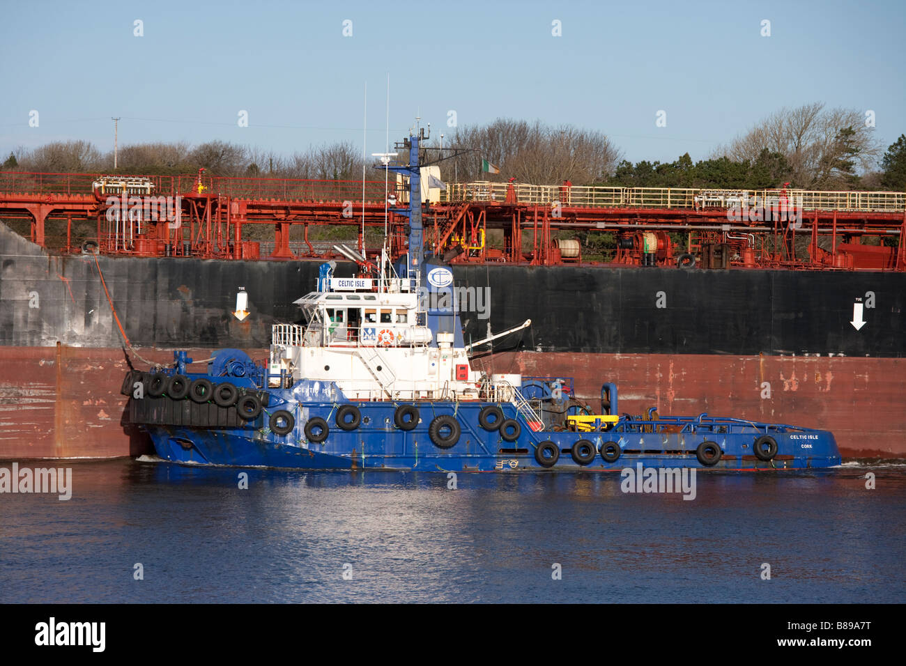Tugboat pushing cargo ship in Foynes Harbour, County Limerick Ireland ...