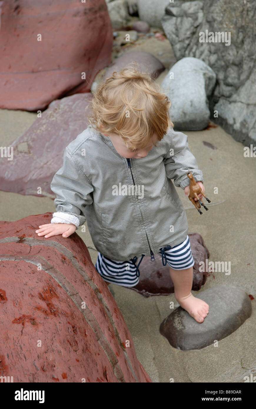 A young boy walks barefoot on a beach Stock Photo - Alamy