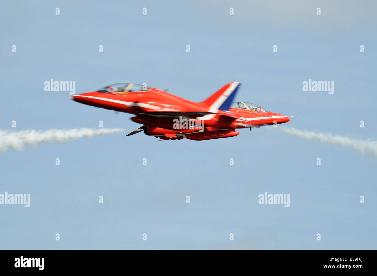 2 Red Arrows Hawk aircraft pass closely at high speed during an airshow ...
