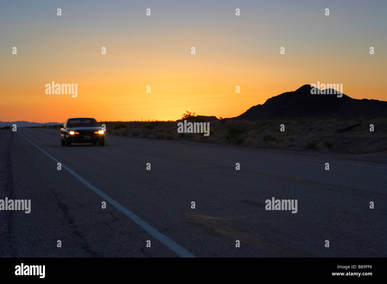 Car on desert road at dusk in Mojave Desert California United States of ...
