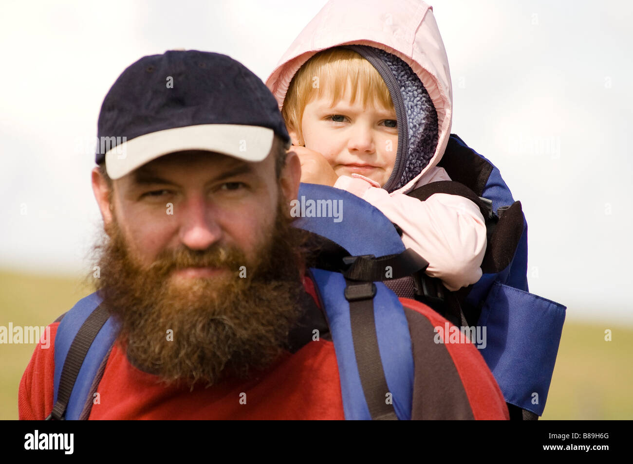 middle aged man carrying his daughter in the kid carrier Stock Photo ...