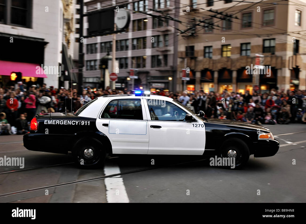 Police car driving in a parade with a crowd watching Stock Photo - Alamy