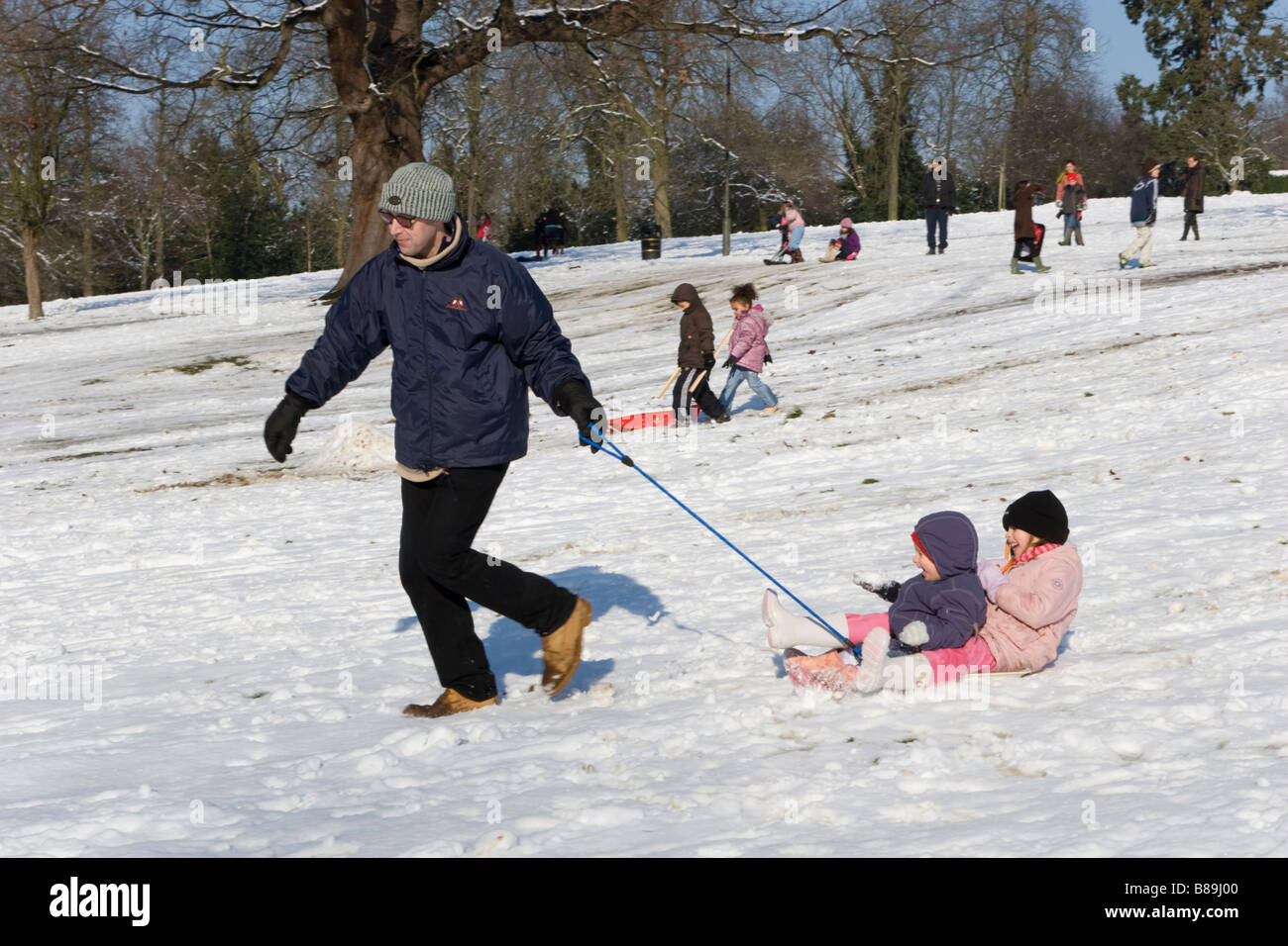 Father and children in snow Stock Photo - Alamy