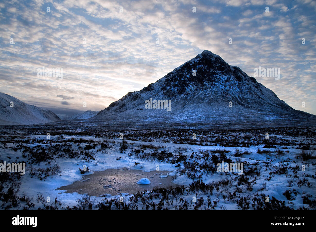 classic winter scene in Scottish Highlands with sun setting behind ...
