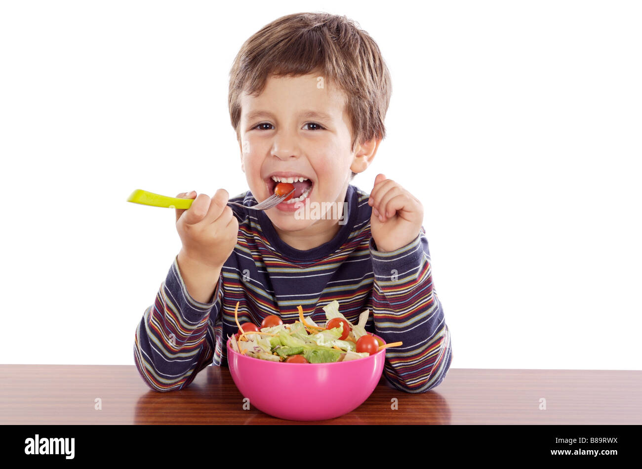 Child eating salad a over white background Stock Photo - Alamy