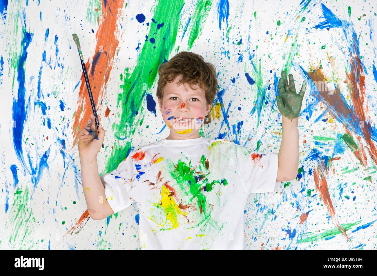 Handsome boy playing with painting with the background painted Stock ...