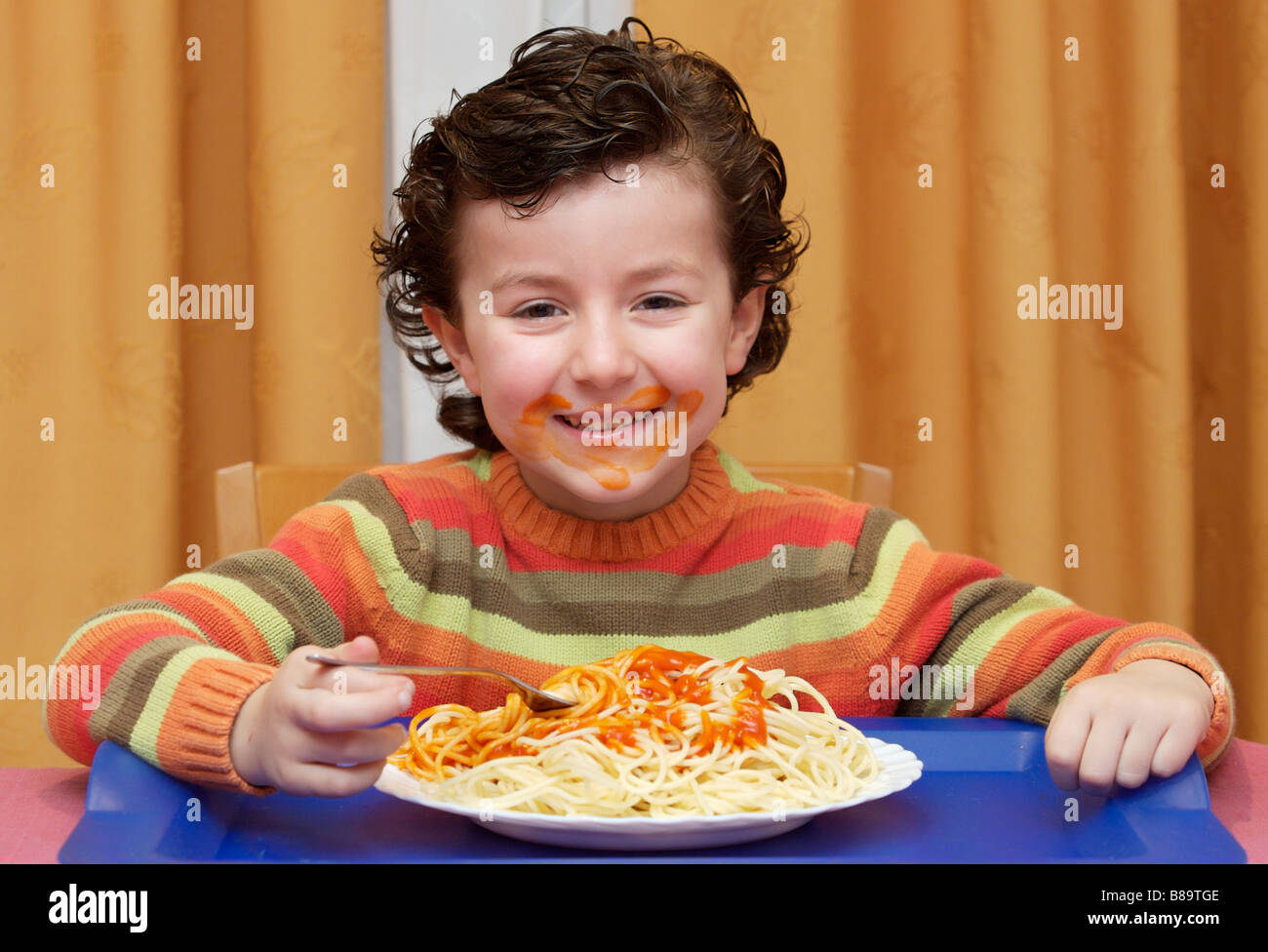 Adorable child eating in his house focus in the face Stock Photo - Alamy