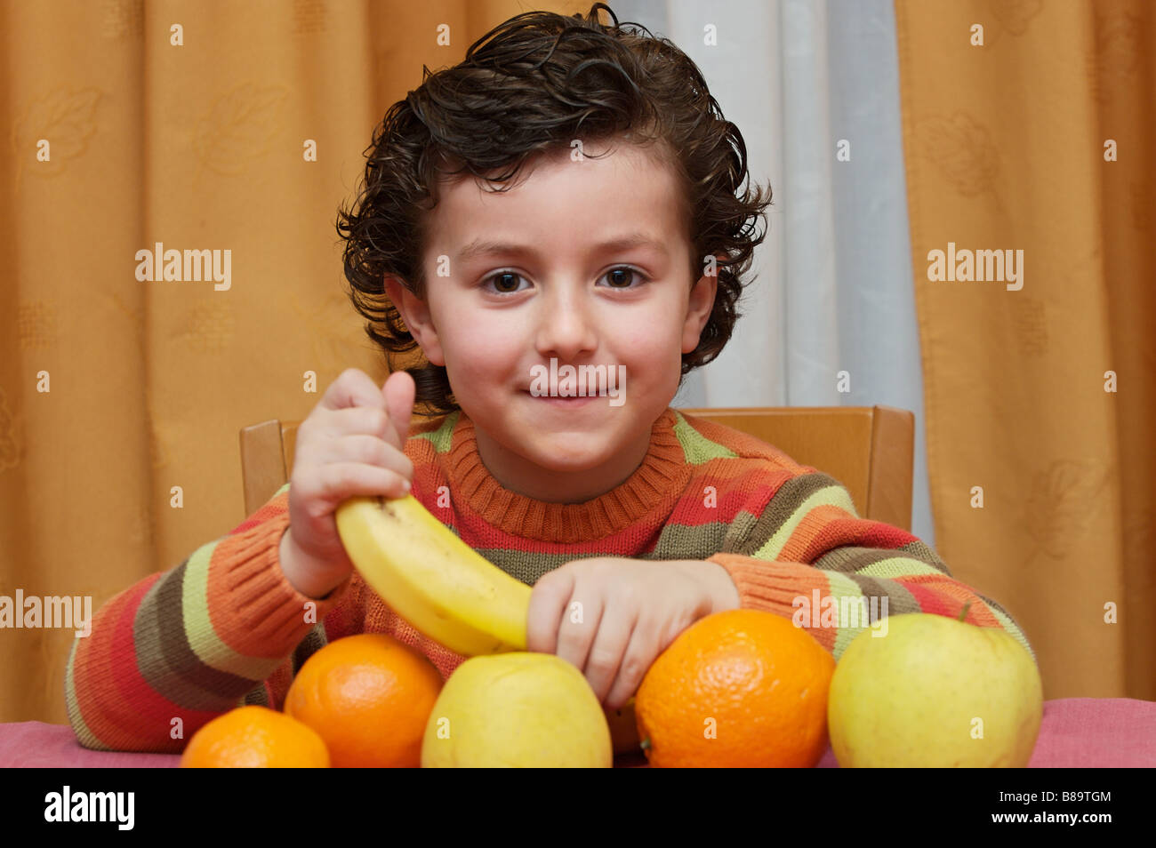 Adorable child eating fruit focus in the face Stock Photo - Alamy
