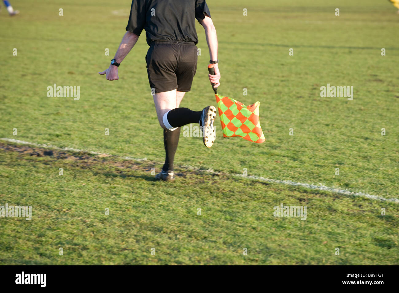 Linesman runs up the edge of pitch during football match Stock Photo ...