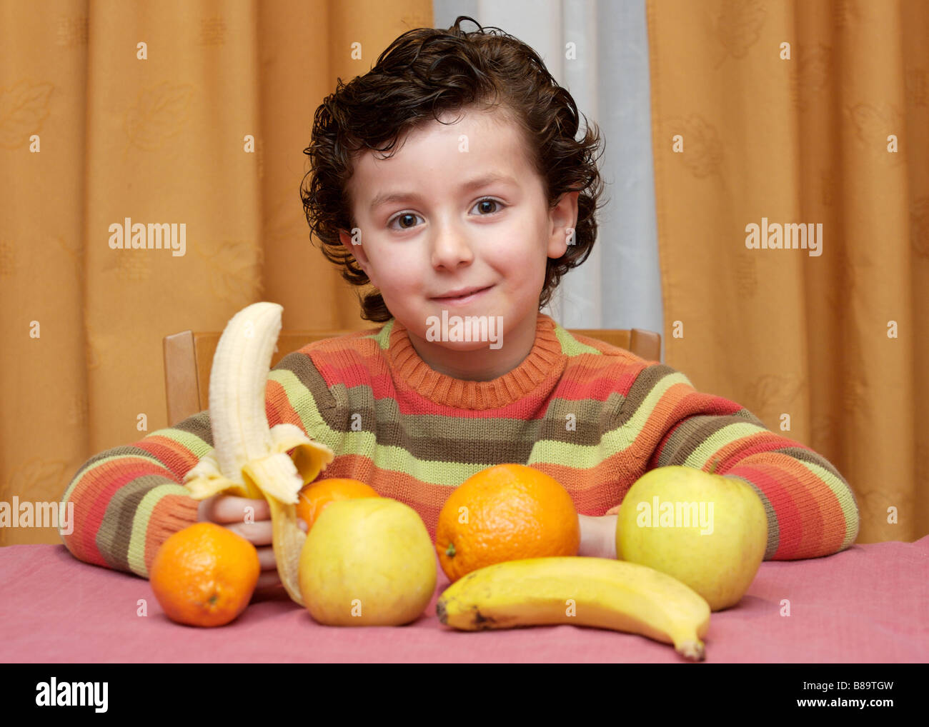 Adorable child eating fruit focus in the face Stock Photo - Alamy