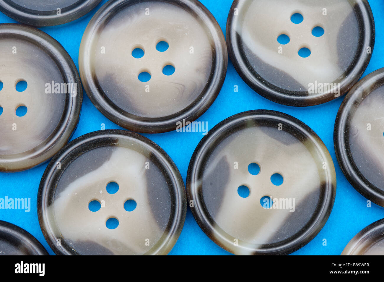group of buttons with four holes on a blue background Stock Photo - Alamy