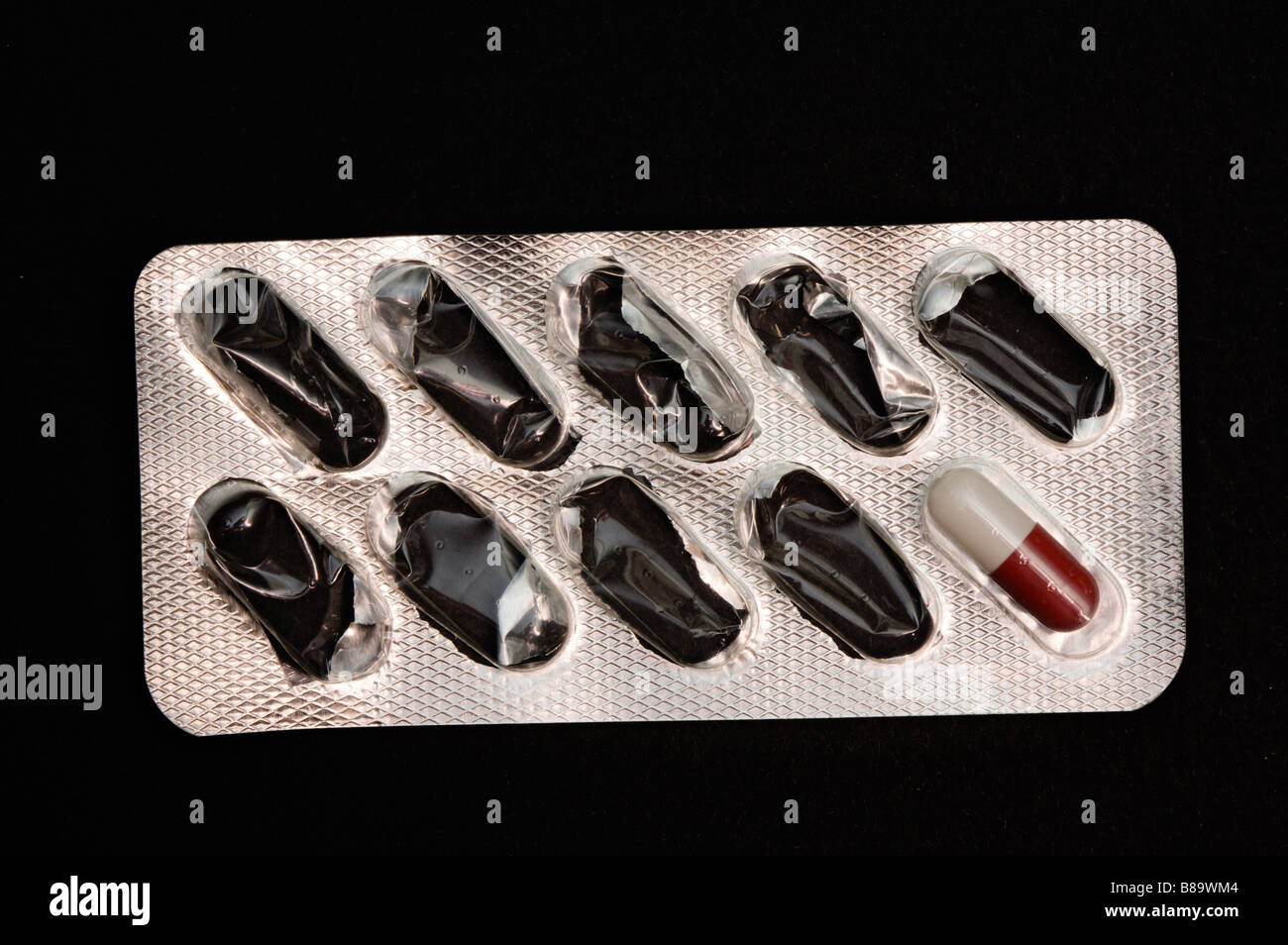 Silver package of pills spent on a black background Stock Photo - Alamy