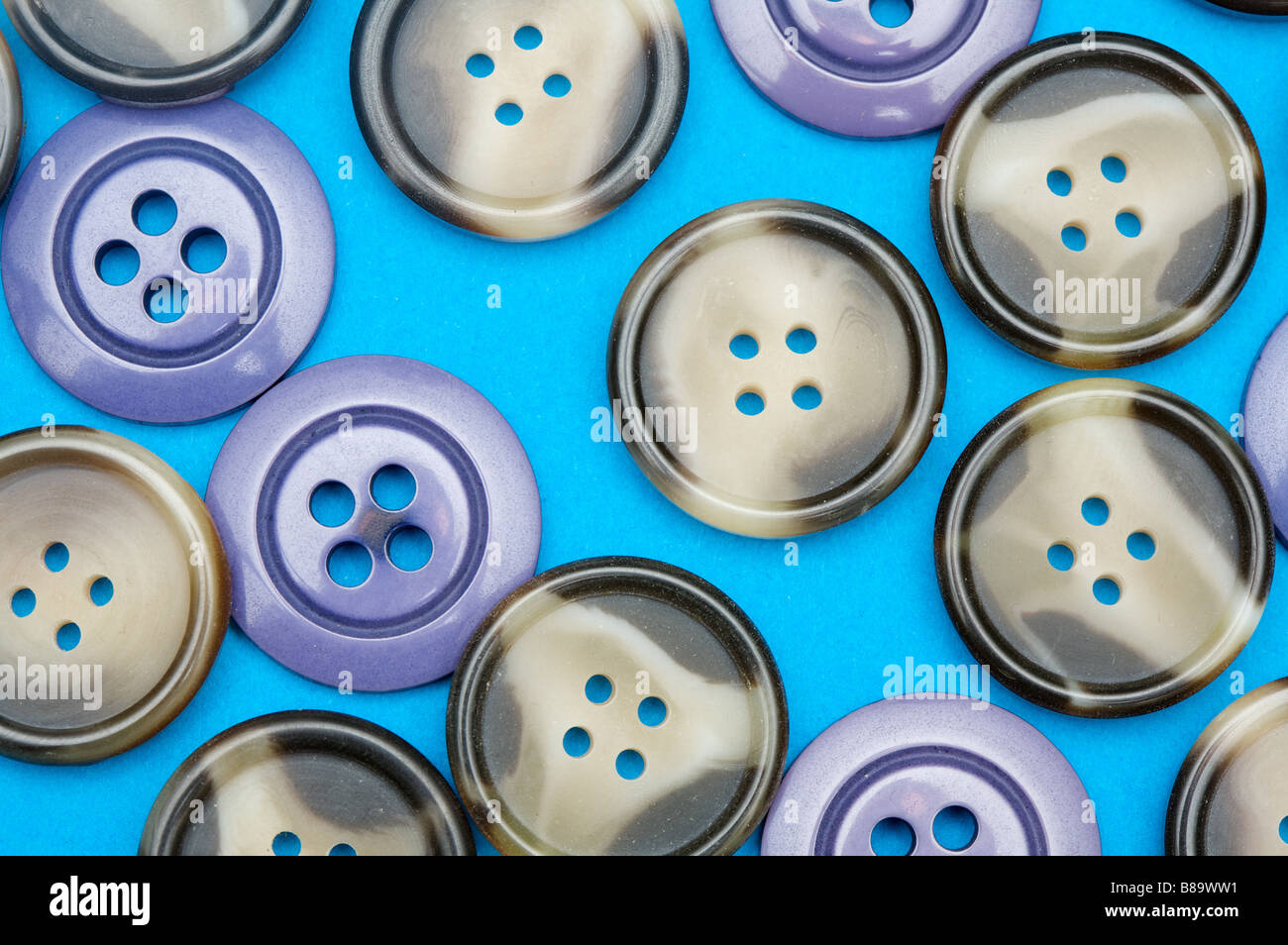 group of buttons with four holes on a blue background Stock Photo - Alamy