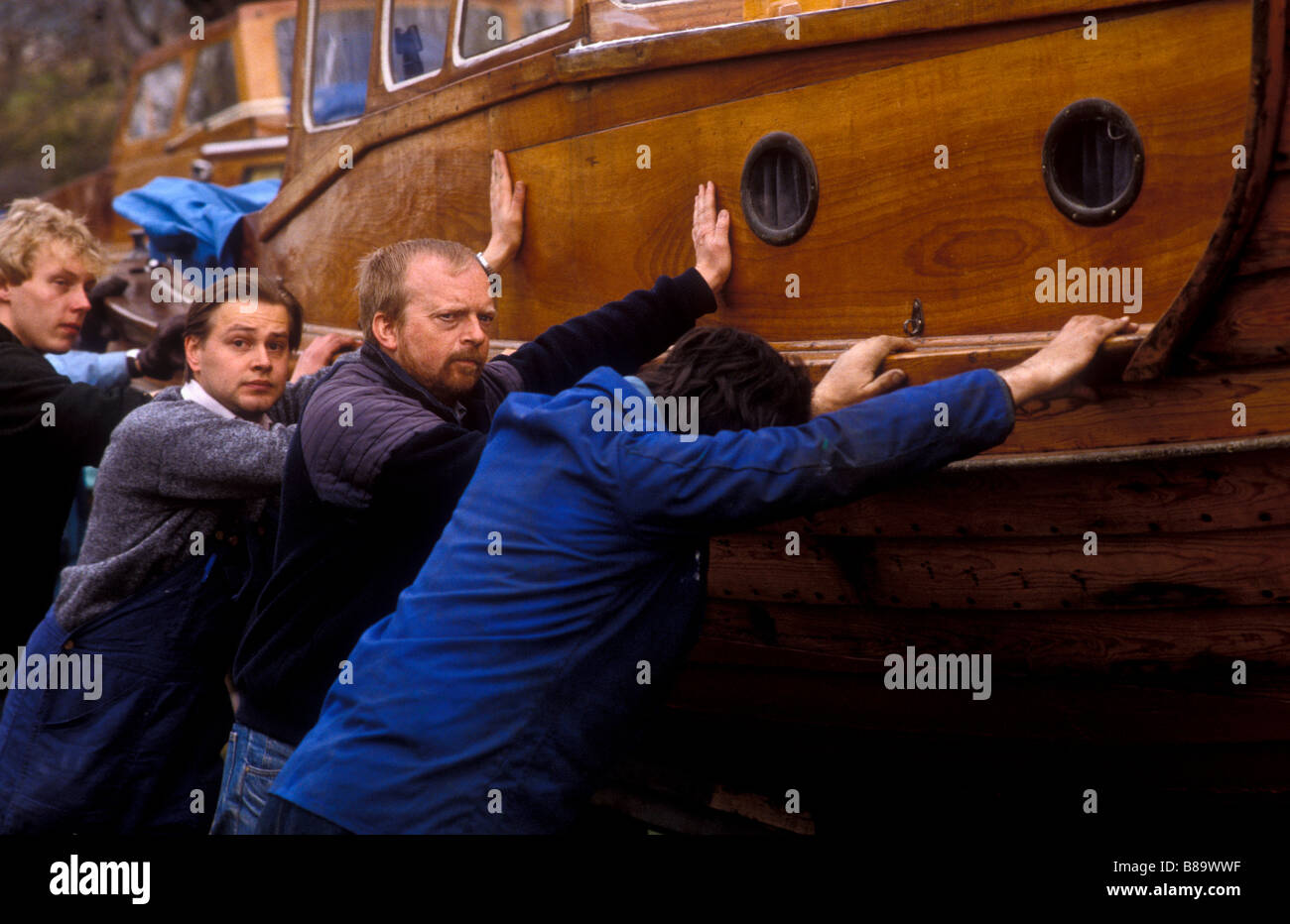 Members help eachother at the spring launching of an old wooden boat in ...