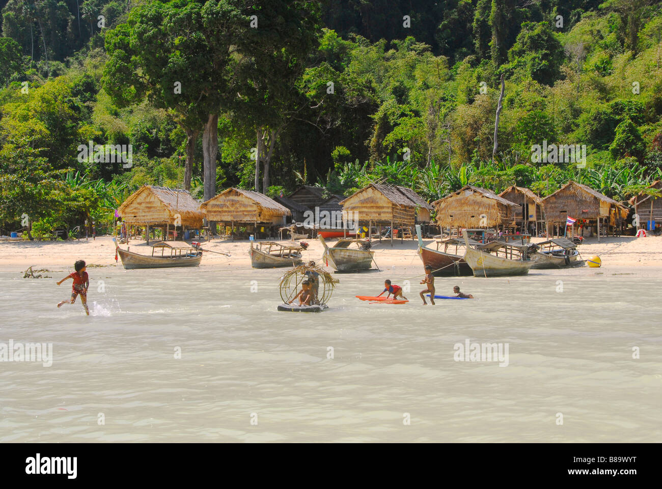 Moken sea gypsy kids enjoy playing in the sea in front of the village ...