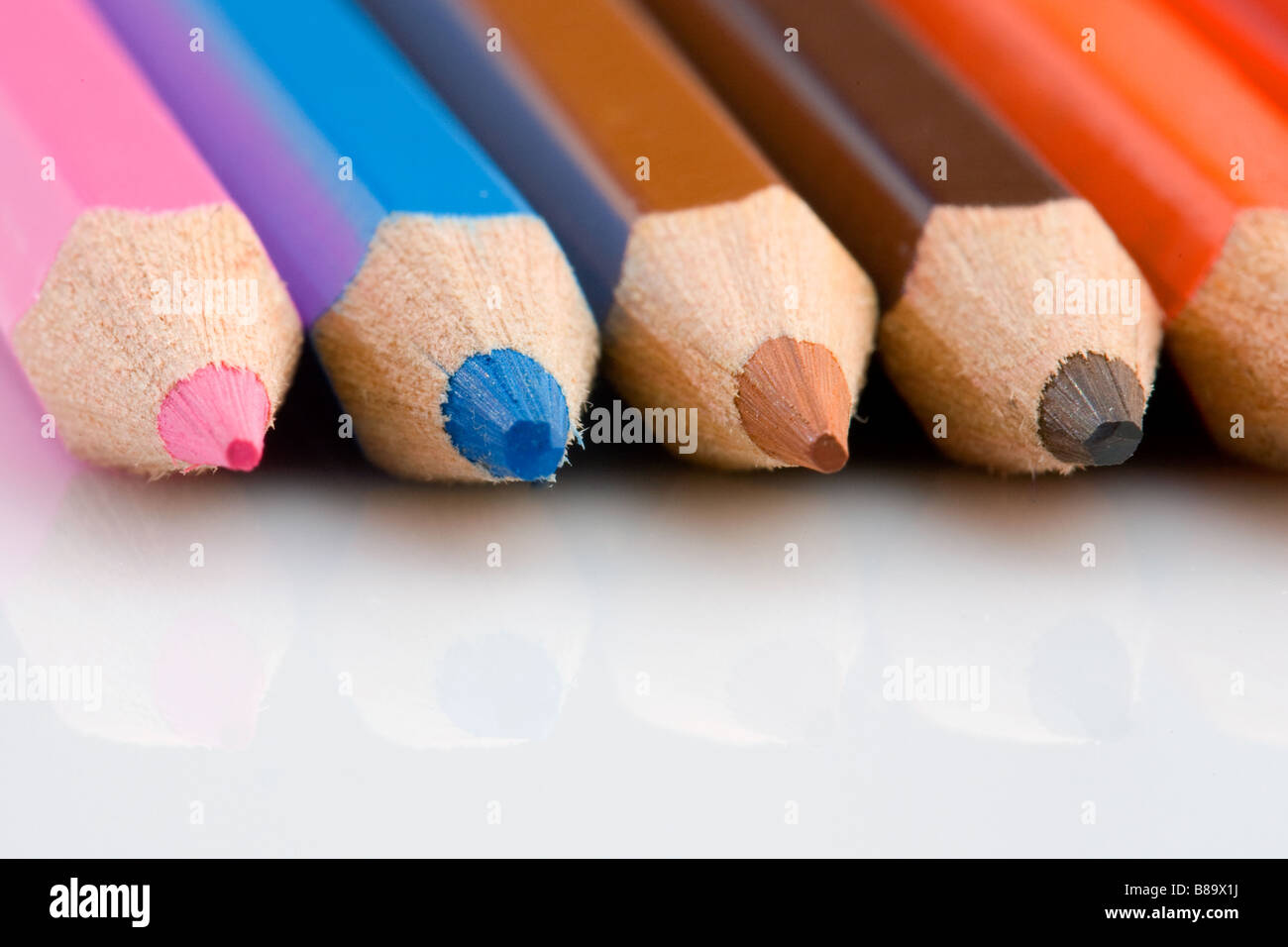 Pencils of many colors aligned with reflection on floor Stock Photo - Alamy