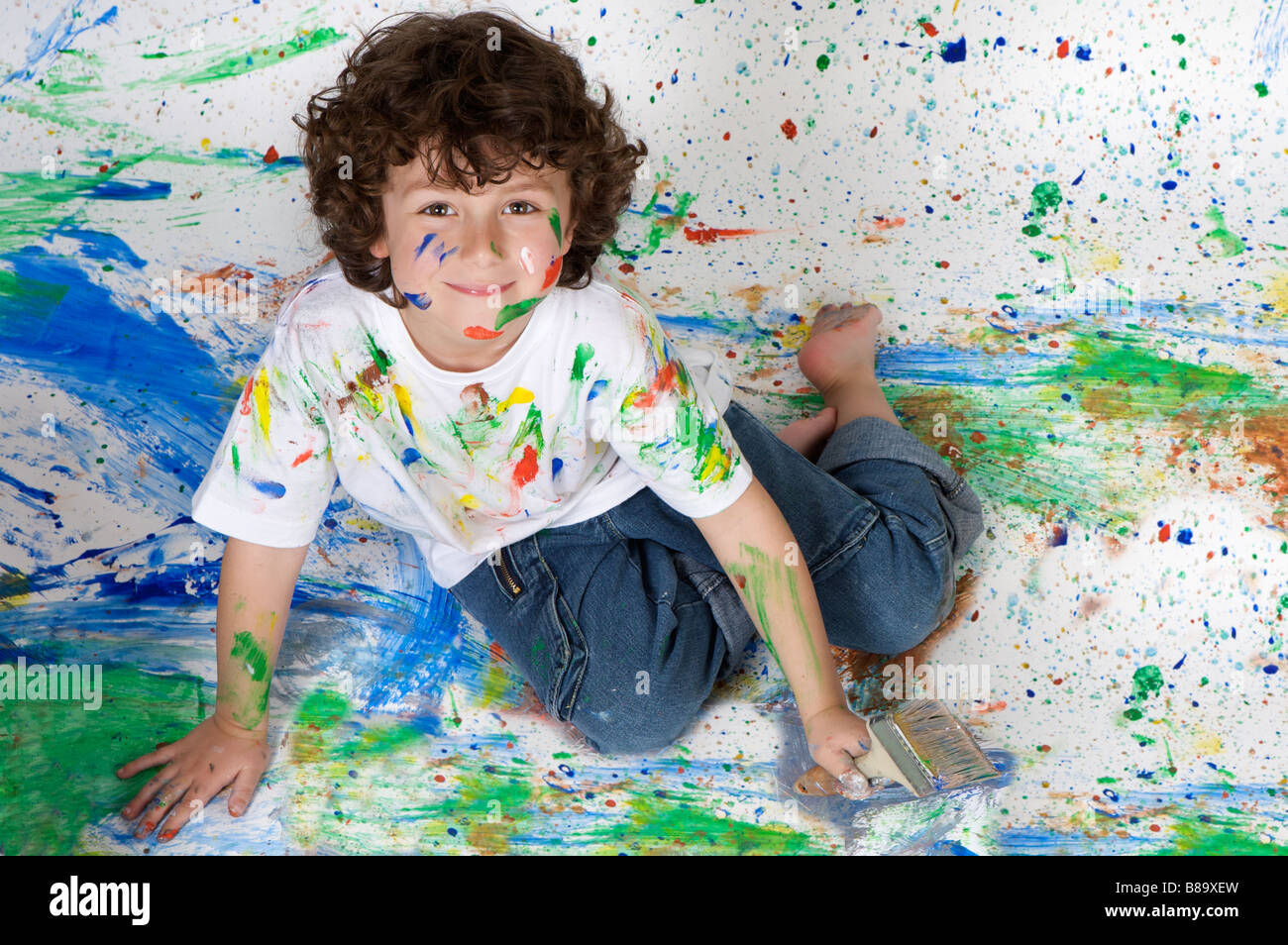 Beautiful boy playing with painting with the background painted Stock ...