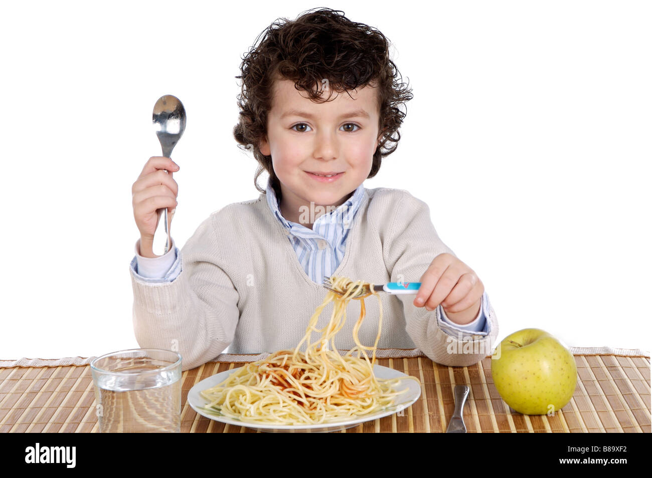 Precious child eating spaghetti on a white background Stock Photo - Alamy
