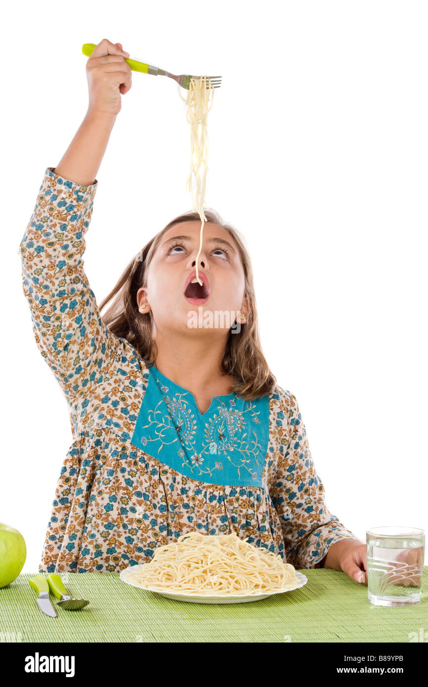Precious girl eating spaghetti on a white background Stock Photo - Alamy