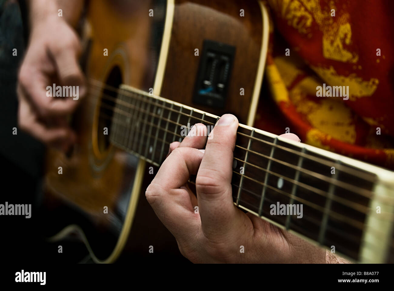 A close up of a guitarists hands playing acoustic guitar Narrow depth ...