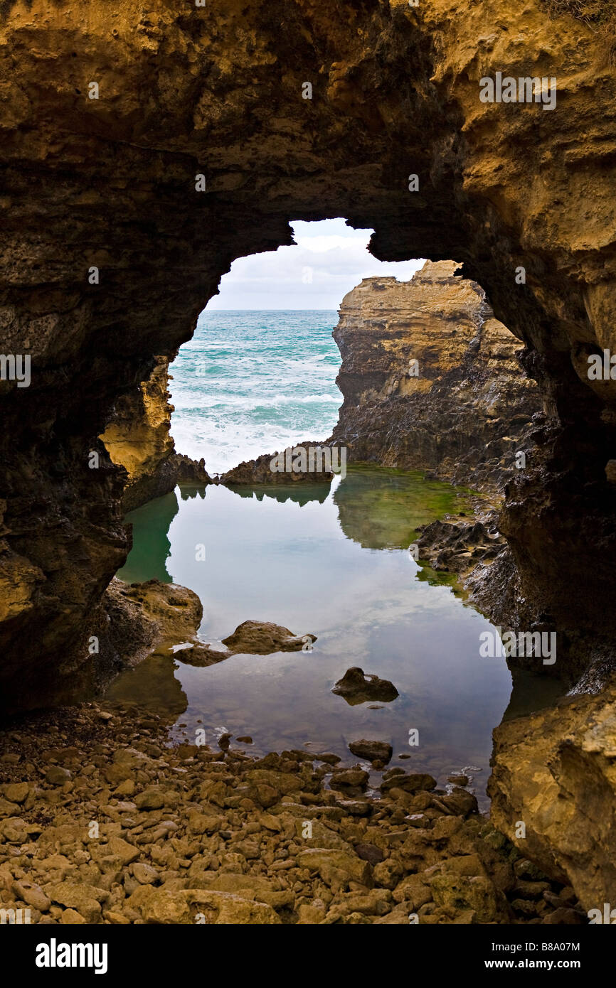 A rock pool and view through a rock opening towards the ocean on ...