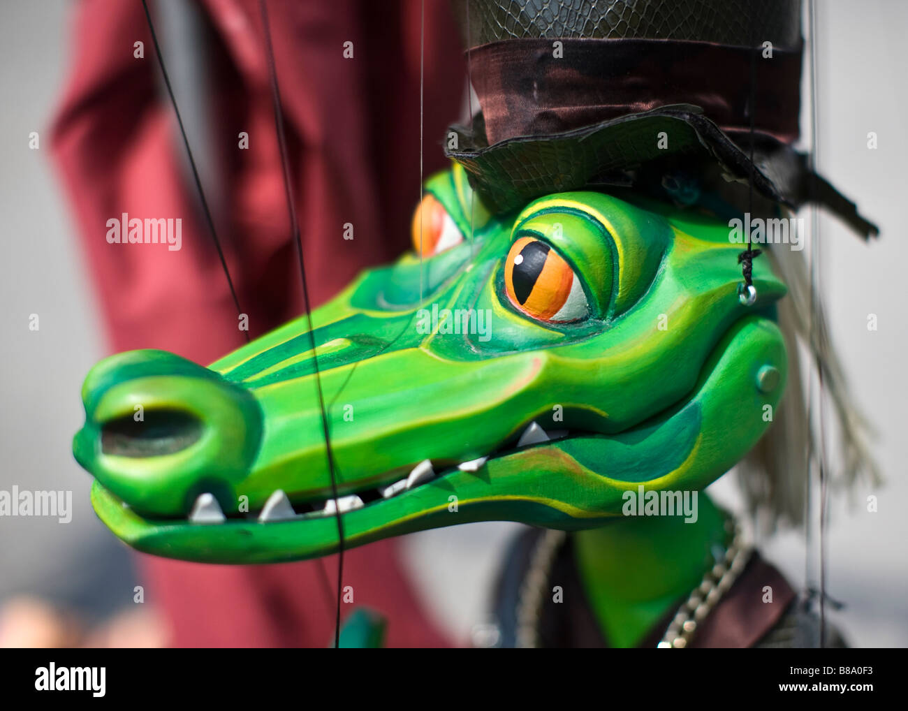 A green wooden crocodile string puppet on display in a street ...