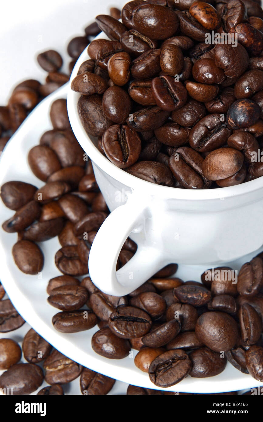 Coffee beans in a white cup overflows Stock Photo - Alamy