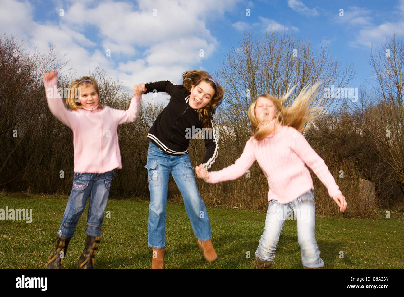 Three jumping girls 6 9 and 11 years old Stock Photo - Alamy