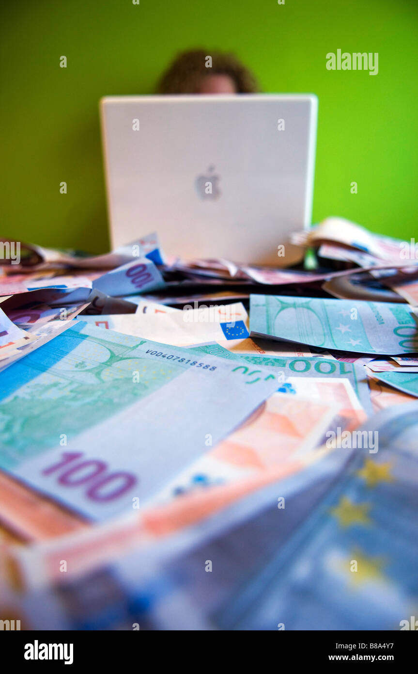 Woman behind laptop computer and euro bank notes around. Winning money ...