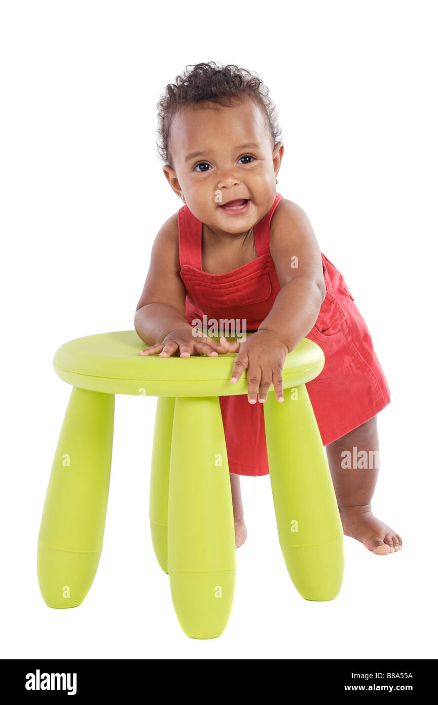 Toddler playing with a chair a over white background Stock Photo - Alamy