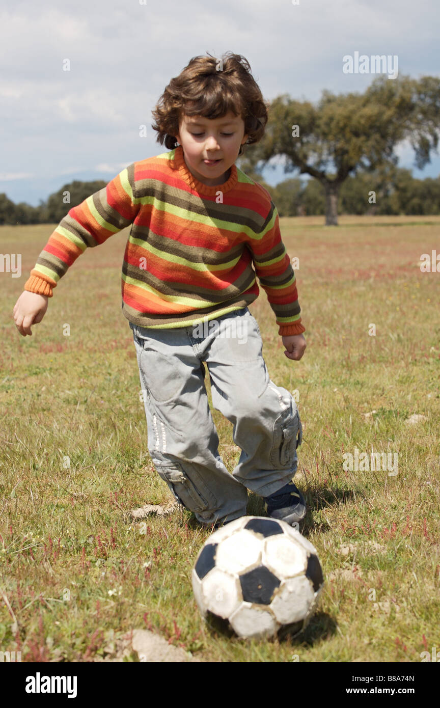 Small child playing football short depth of field Stock Photo - Alamy
