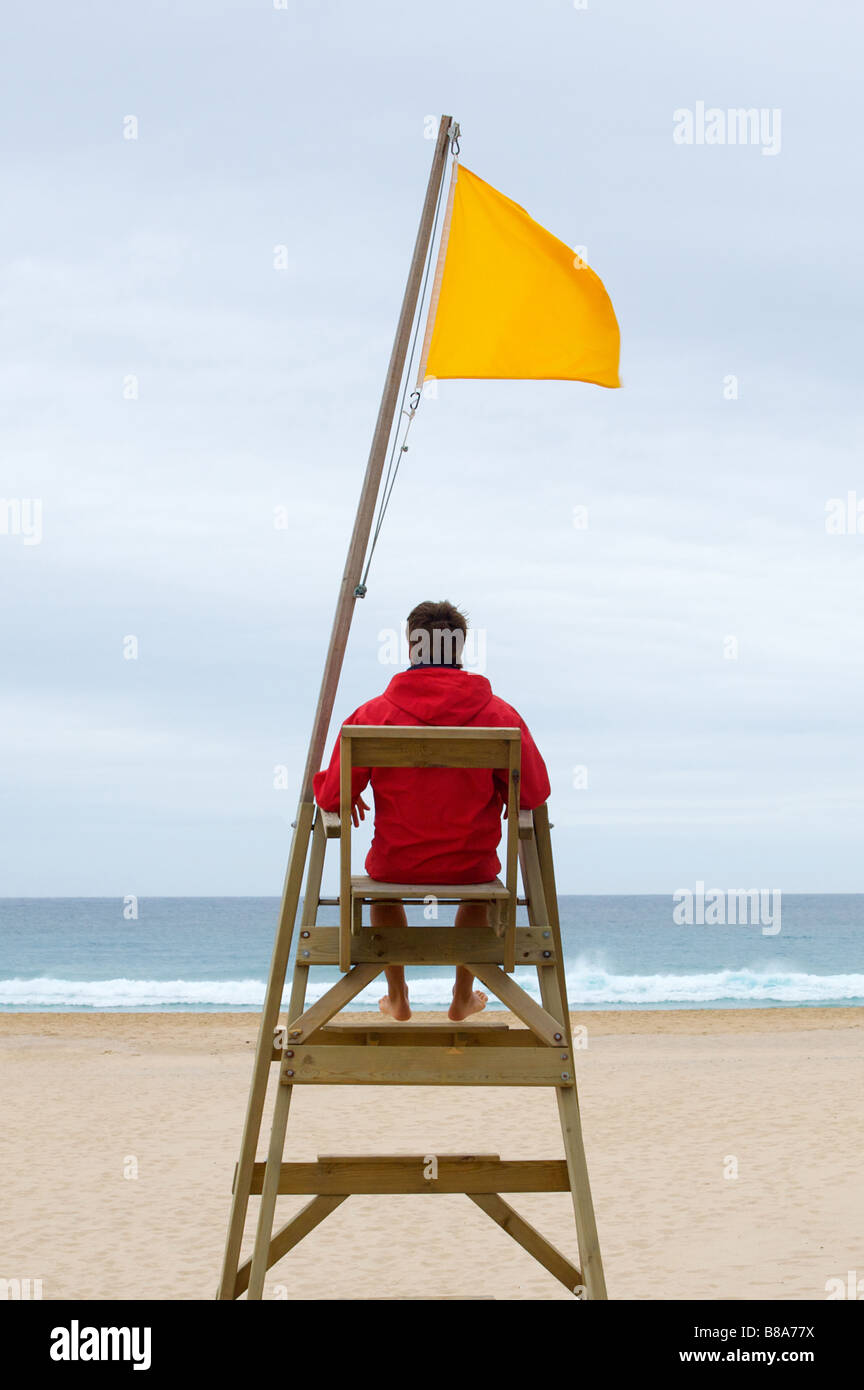 Lifeguard sitting in his chair watching the sea Stock Photo - Alamy