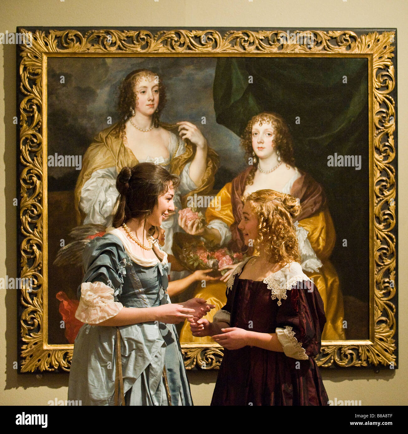 Two women wearing seventeenth-century costumes chatting in front of a ...