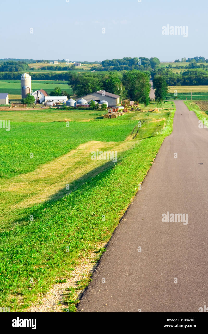 Summer field and road with farm in background Stock Photo - Alamy