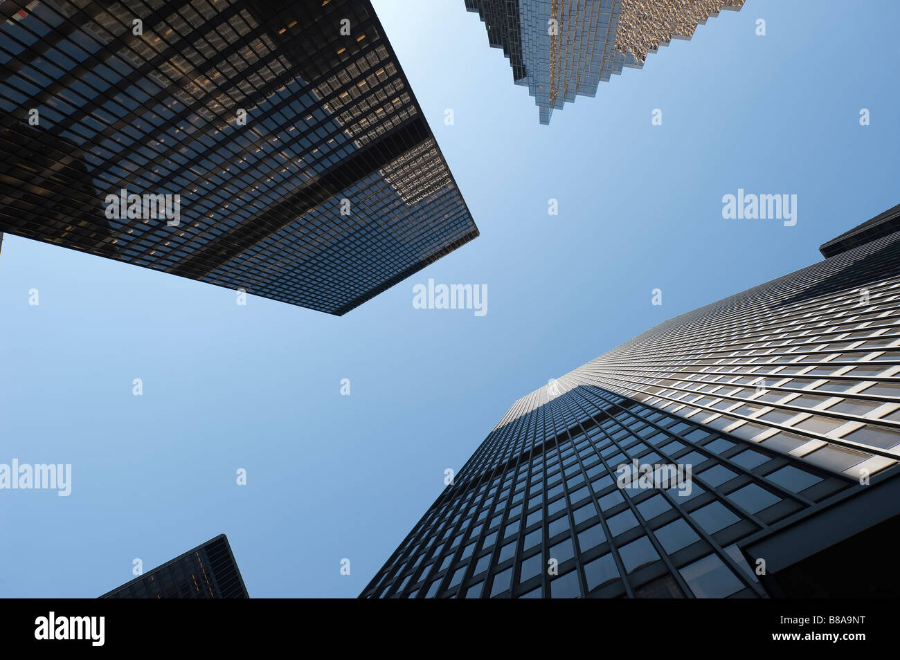 Looking straight up between several highrise buildings in a downtown ...